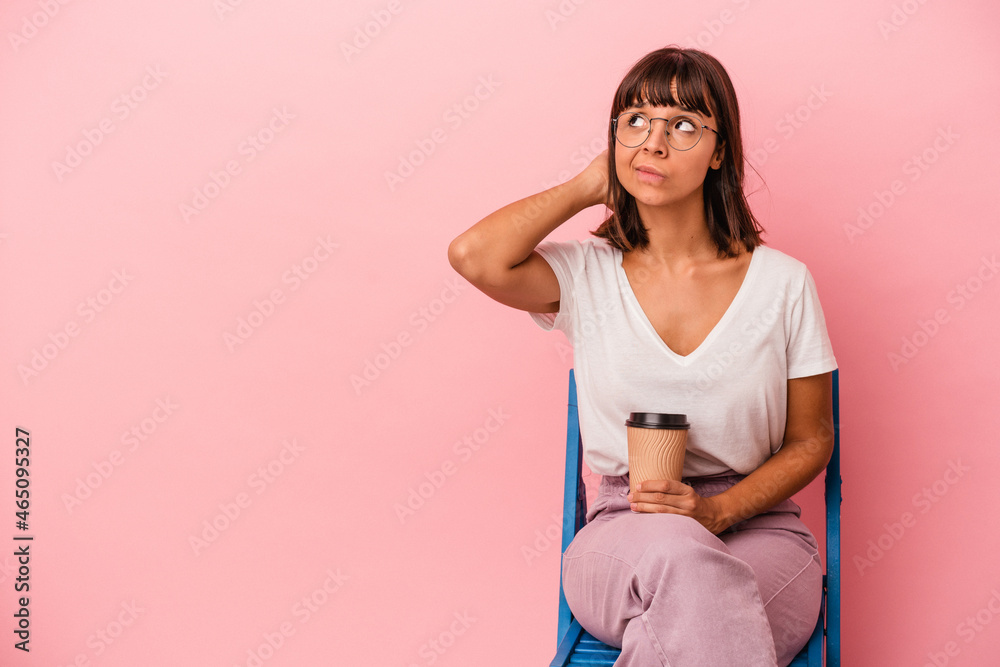 Young mixed race woman sitting on a chair holding a coffee isolated on ...
