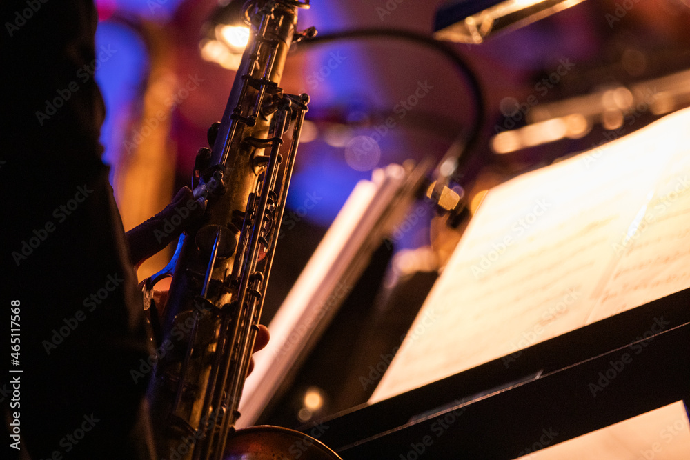 Poster A tenor saxophone player playing a solo in front of a microphone ...