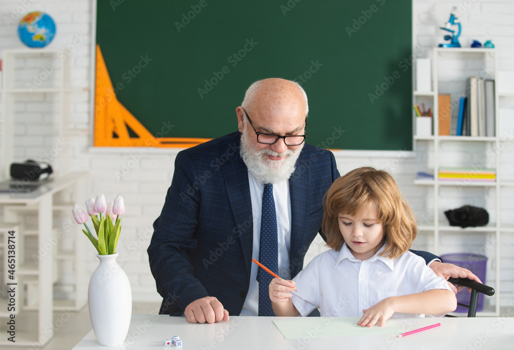 Cute young child in class at school. Senior teacher and at home working ...