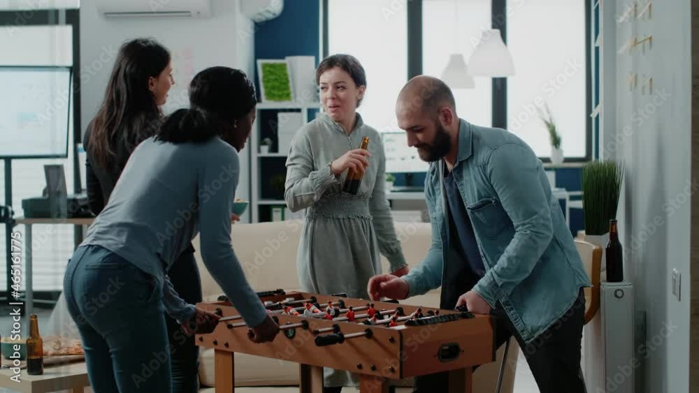 Diverse group of workmates enjoying game with foosball table to do fun ...