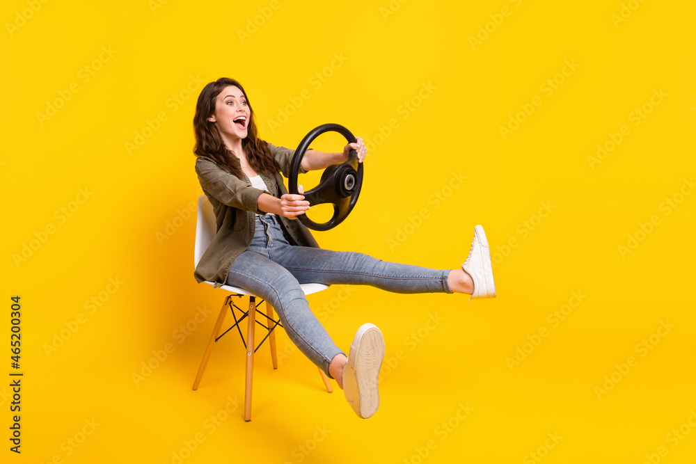 Portrait of nice funny cheerful girl sitting on chair holding steering ...
