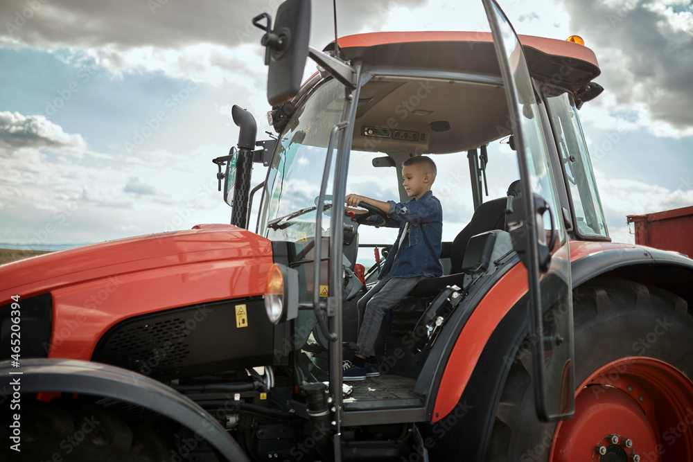 Boy driving tractor in field Stock Photo | Adobe Stock