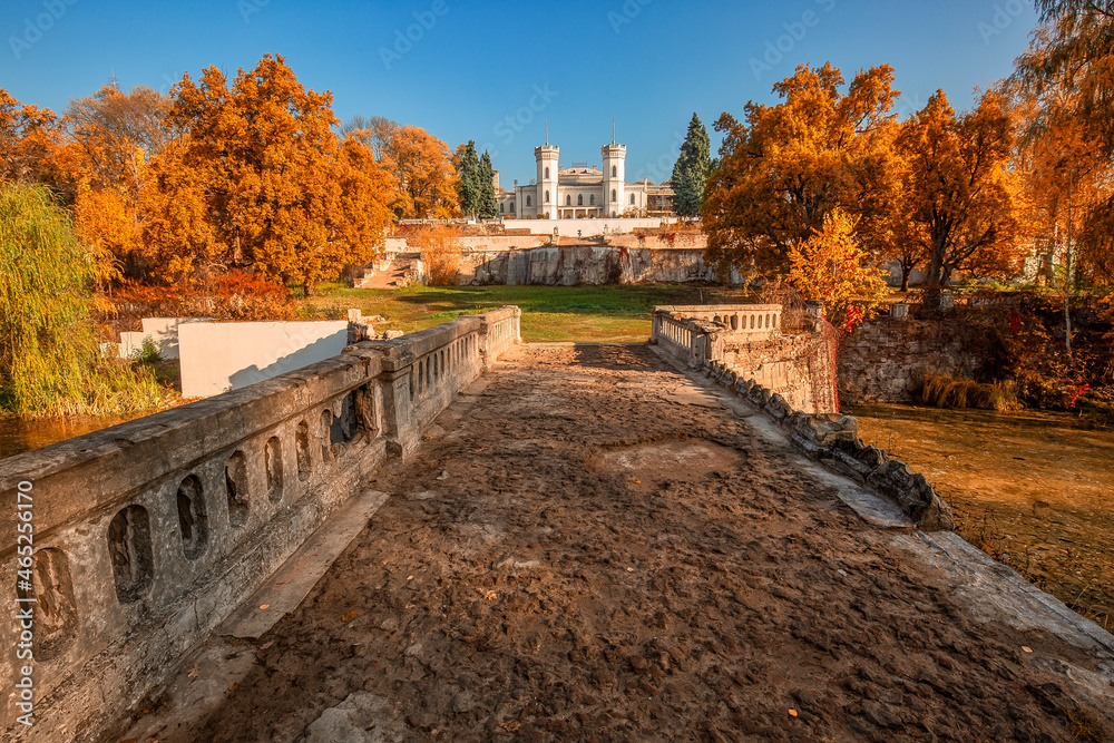 Beautiful old white castle surrounded by landscape park, fall season ...