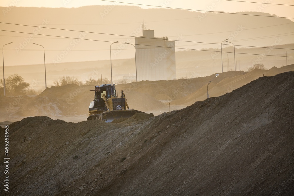 Crawler excavator front view digging on demolition site in backlight ...
