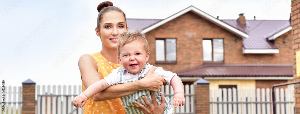 Mother and baby in front of the house. Family portrait outside new home ...