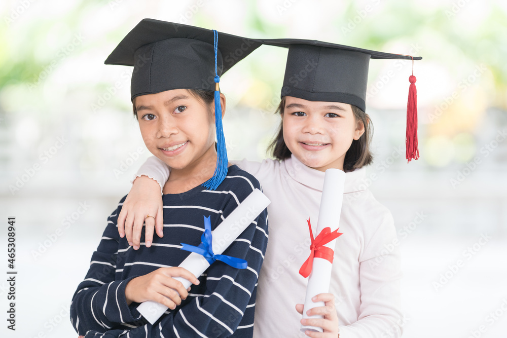Happy Asian female school kid graduates with a graduation cap hold a ...