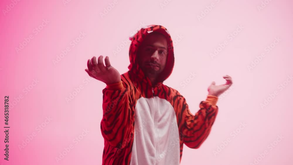 Man wearing tiger costume dancing on colorful background. Symbol of ...