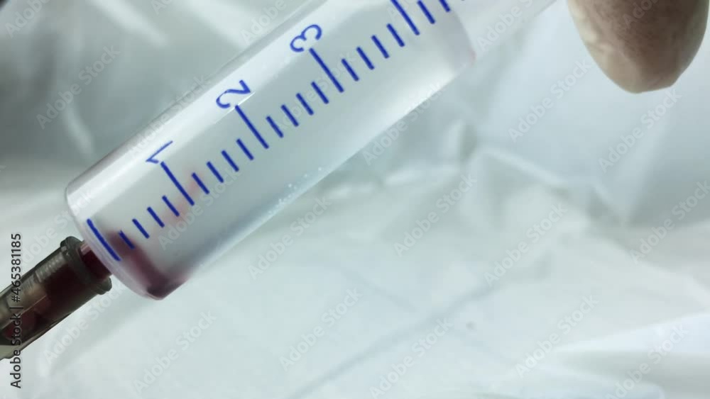 The red liquid is drawn into a syringe. Blood is diluted with water ...