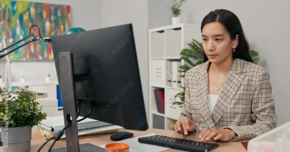 Vídeo do Stock: An attractive, experienced company accountant sits in office in front of a ...