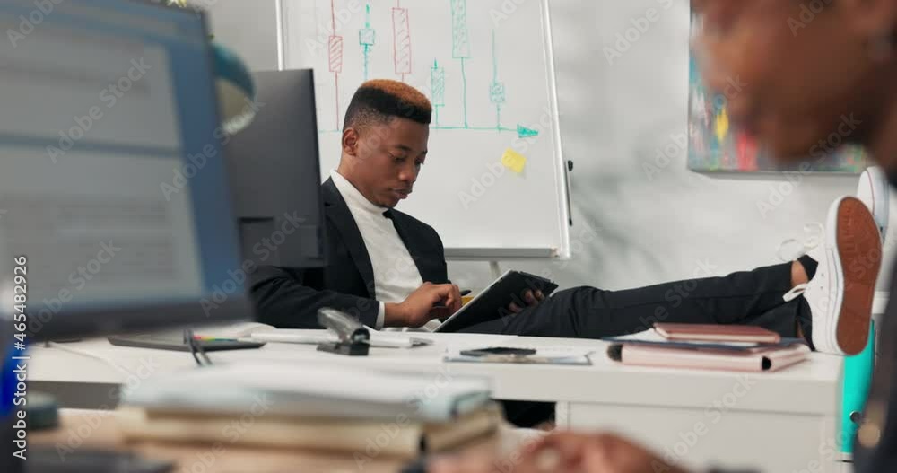 Relaxed dark-skinned boss is sitting in armchair with feet on desk ...
