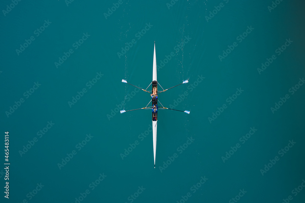White rowing boat in motion with two women, top view. Top view of the ...