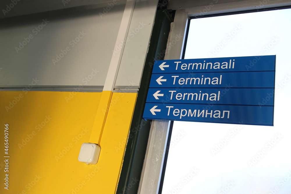 sign indicating the way to the airport terminal building in different ...