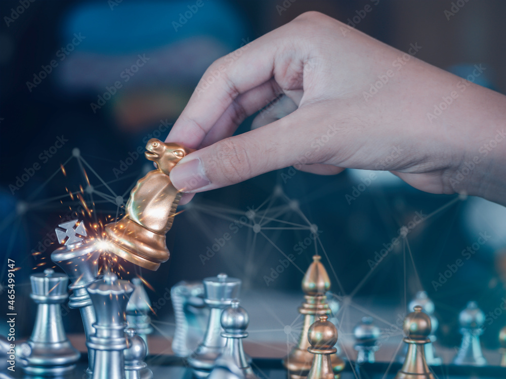 Hand businessman moving the golden knight chess fighting silver knight ...