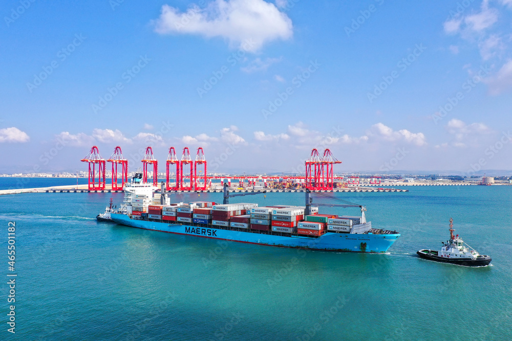 Tug boat directing a Maersk Container ship into a port dock. Stock ...