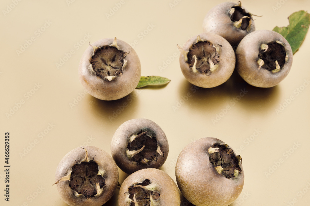 Reife Mispeln auf einem gleichfarbigen goldenen Hintergrund, Mespilus ...