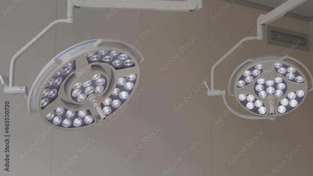 Powerful medical lamps shining in the empty operating room at the ...