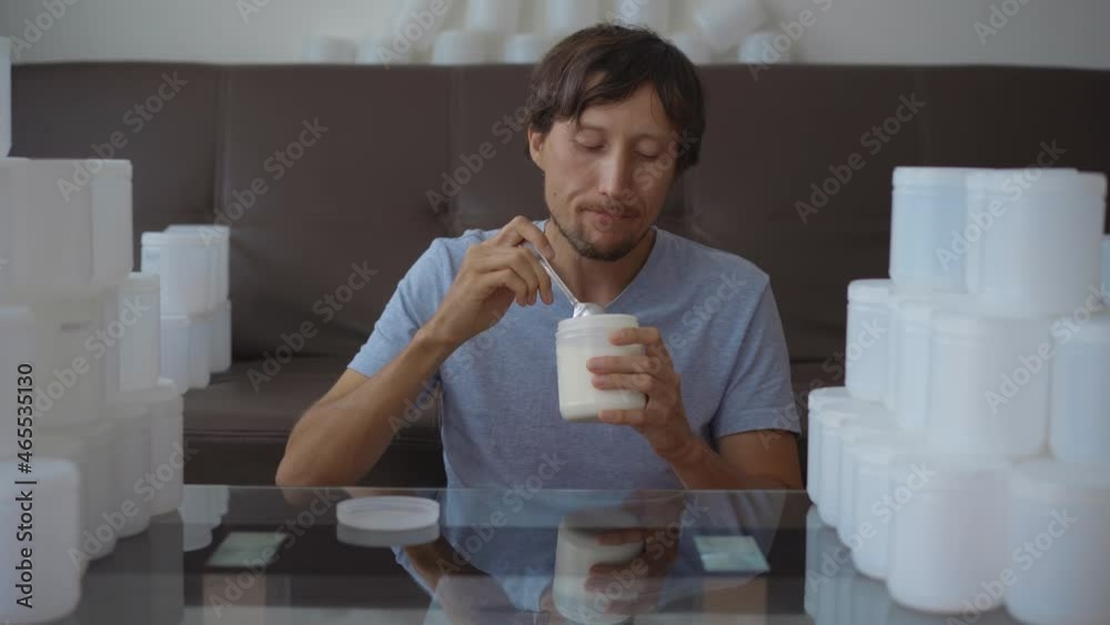 Vidéo Stock A man is eating yogurt from a white plastic can. Camera ...