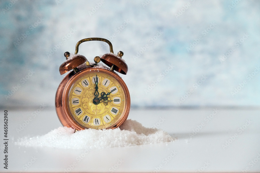Vintage alarm clock in artificial snow showing clock change to winter ...