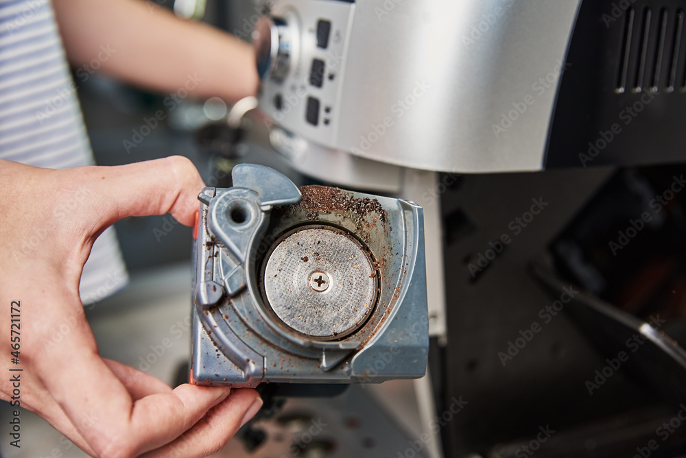 Automatic coffee machine cleaning. Woman cleans mechanism inside coffee ...