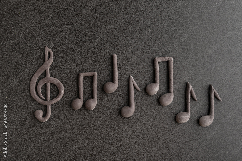 Three-dimensional notes and treble clef on black background. Musical ...