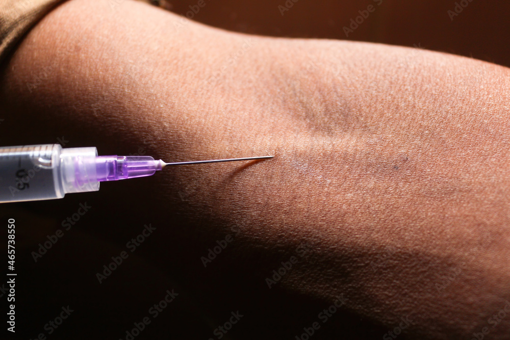 A doctor makes an injection into a vein. Intravenous drug ...