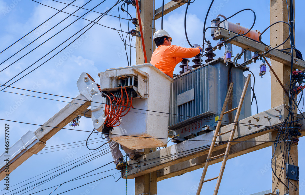 Electrician in bucket of articulated boom lift is repairing electrical ...