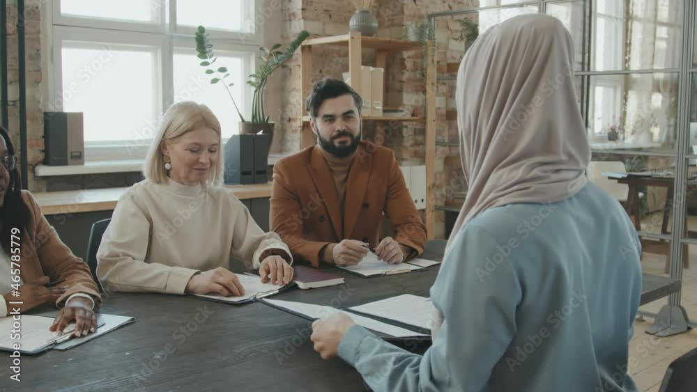 PAN shot of unrecognizable Muslim woman in hijab singing contract and ...