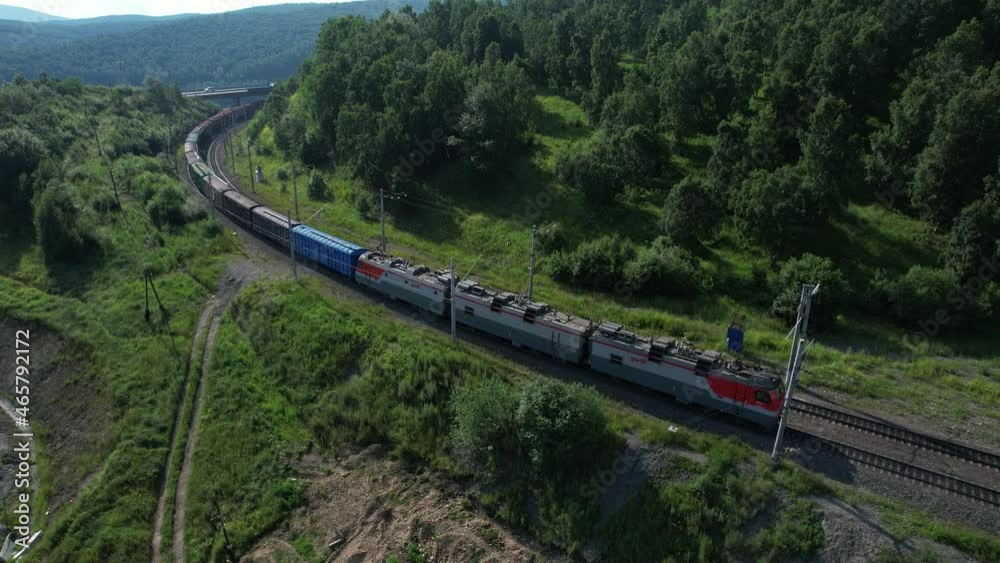 Baikal, Russia - 2021: A passenger train rides along the mountains on a ...