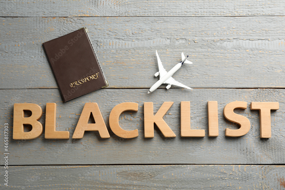Word Blacklist of letters, toy airplane and passport on grey wooden ...