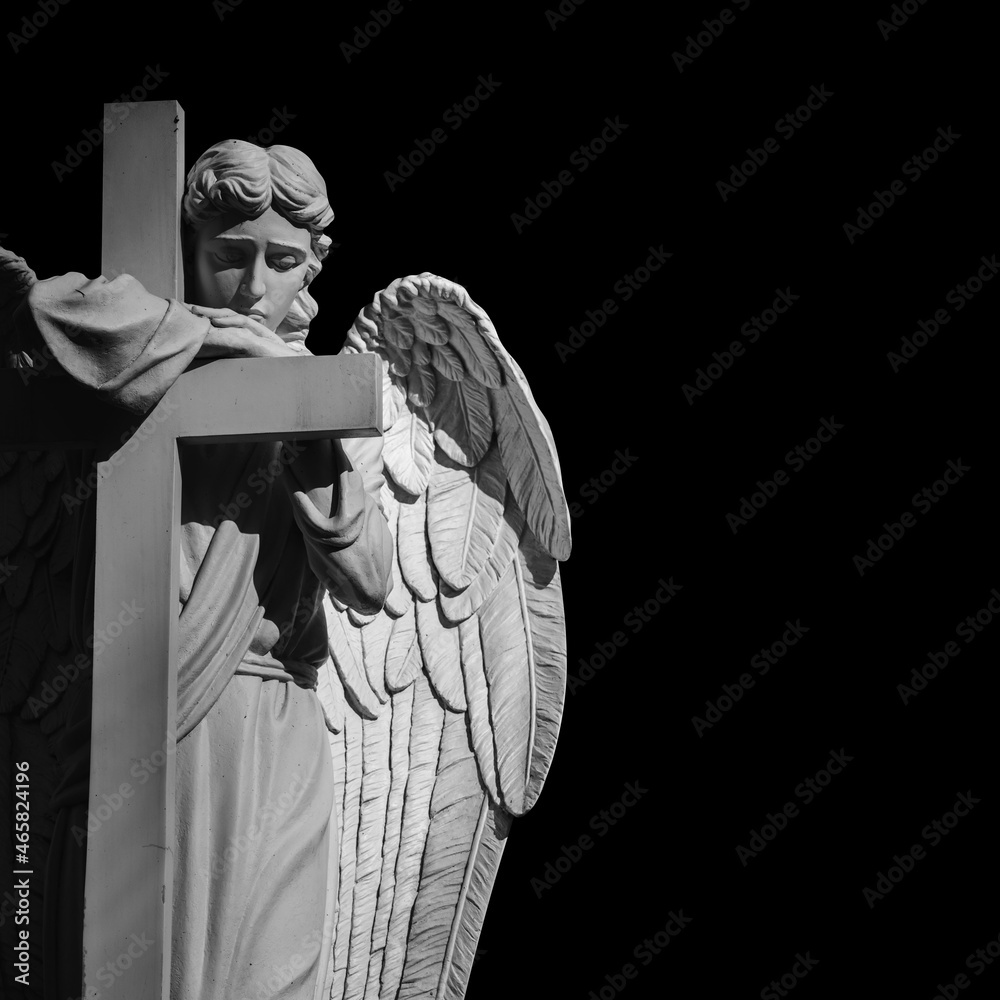 Beautiful sad angel with cross on black background. Fragment of an ...