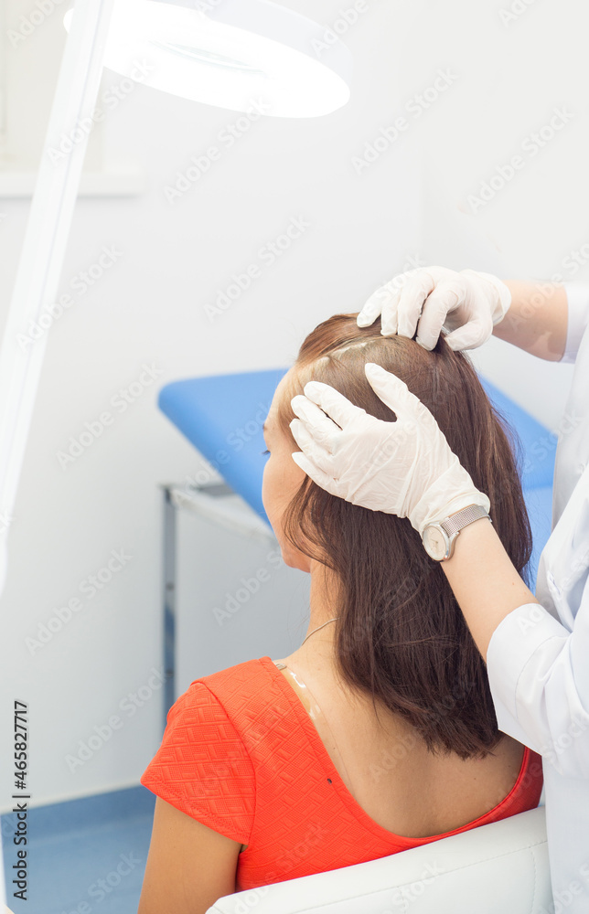 Doctor dermatologist doing hair loss test on female patient with long ...