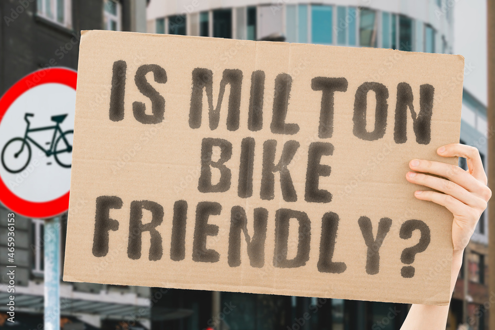 The question " Is Milton bike friendly? " on a banner in men's hand ...