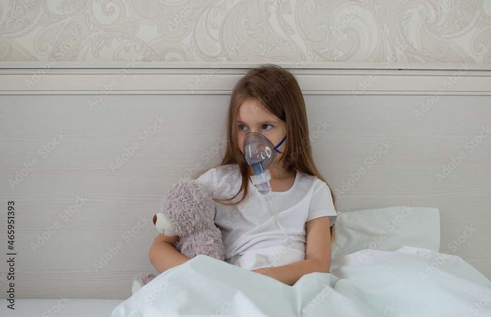 Sick child is sick at home, lying in bed with teddy bear. Does the ...