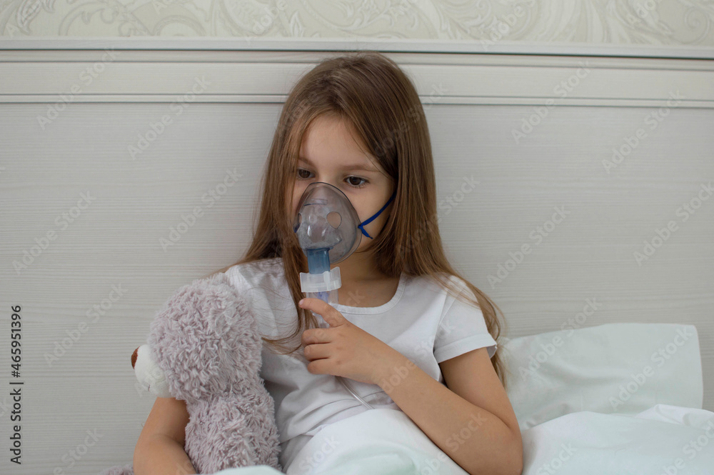 Sick child is sick at home, lying in bed with teddy bear. Does the ...