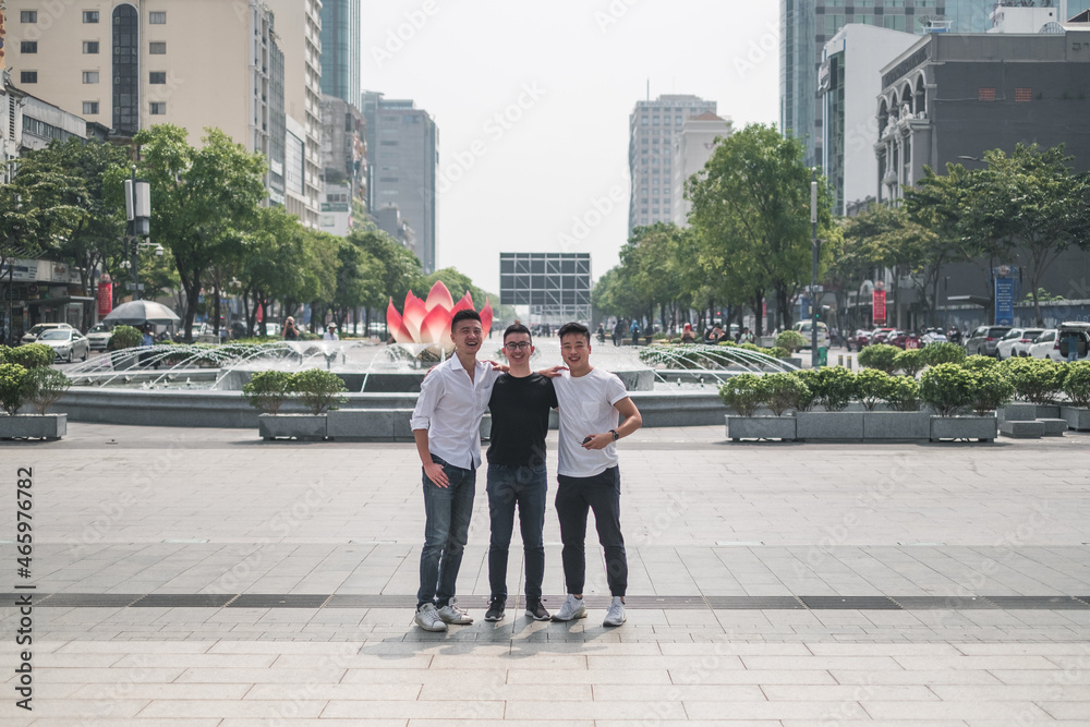Three asian young men standing on the street and smiling. Asia, street ...