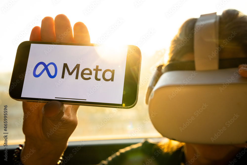 Meta logo on the iPhone, rebranding. Woman holding smartphone with new ...
