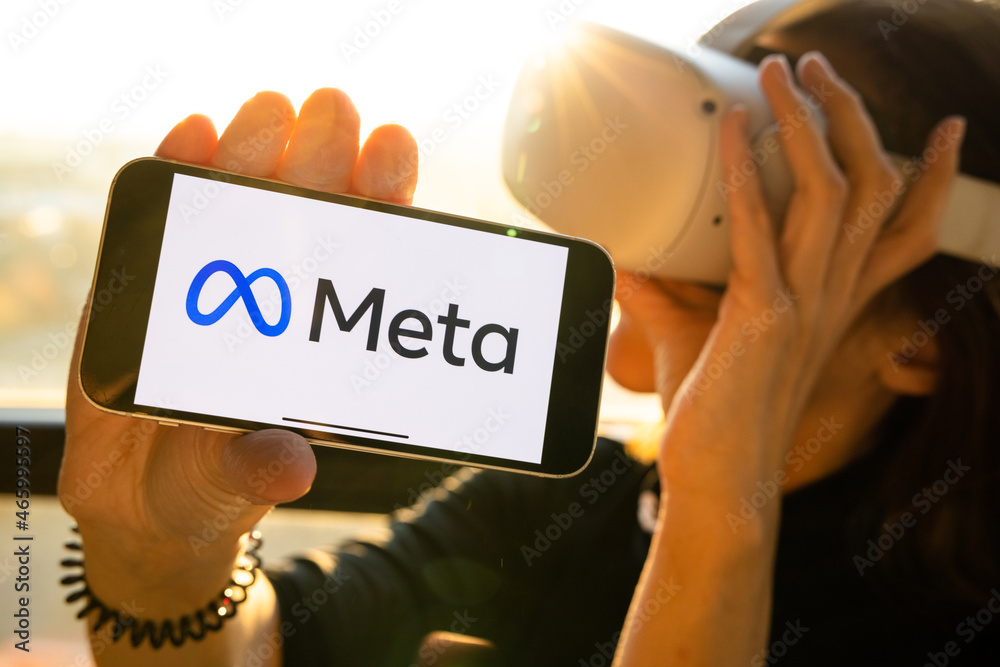 Meta logo on the iPhone, rebranding. Woman holding smartphone with new ...
