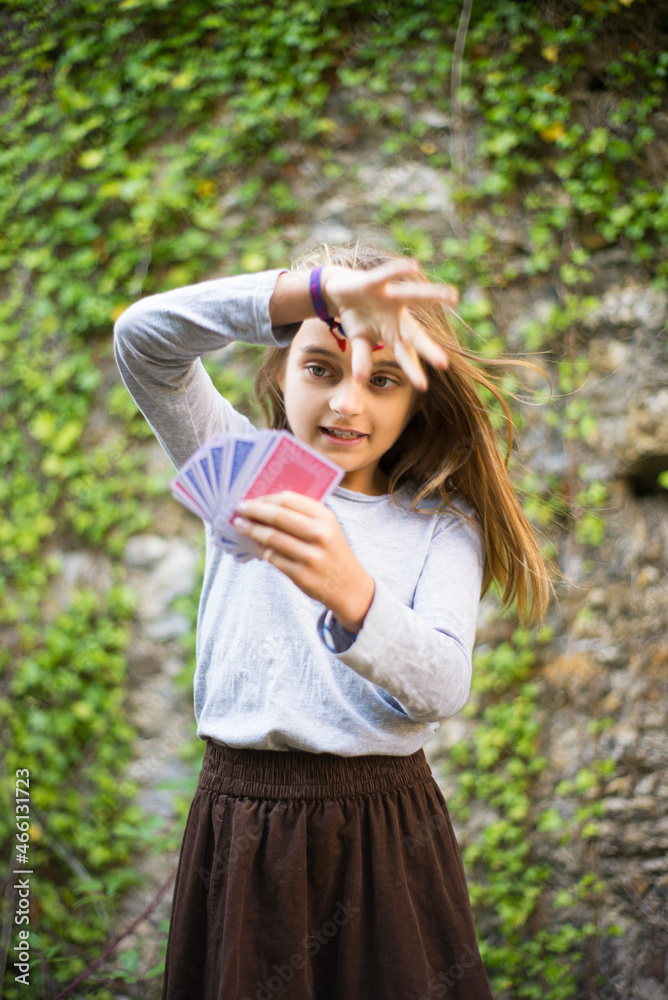 Cute little girl doing magic tricks with cards. Long haired child doing ...