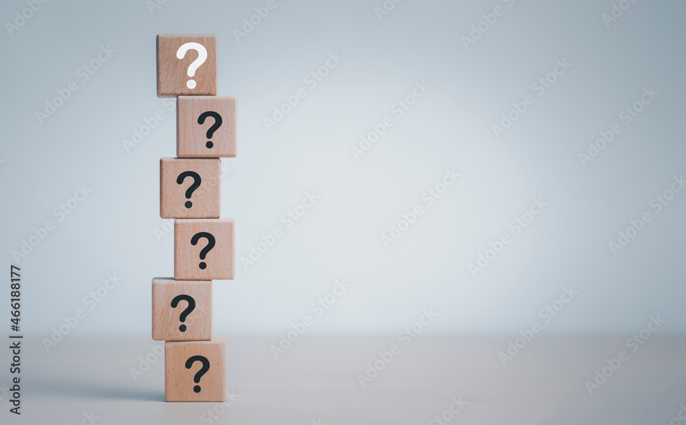 Hand hold Wooden cube block in question mark mean what on cement table ...