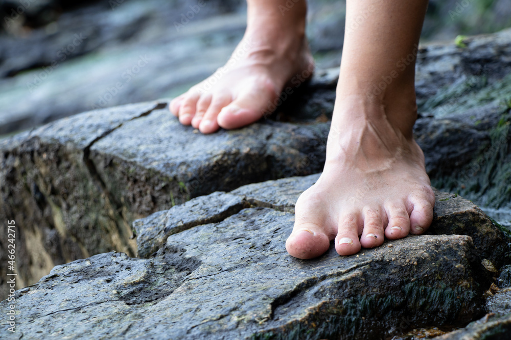 female bare feet on granite stones at the quarry, bare feet on the ...