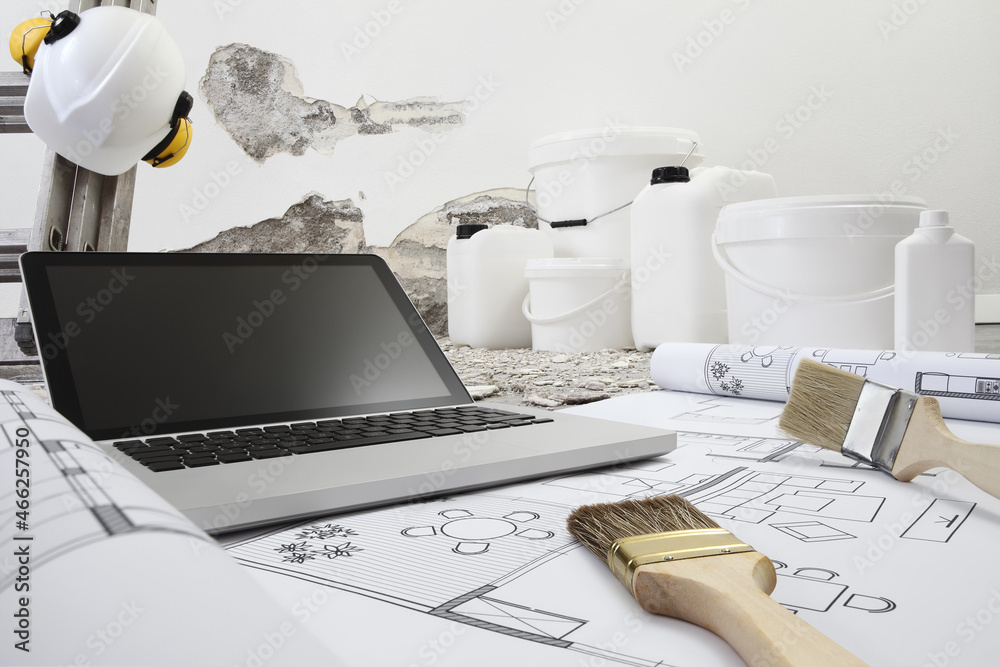 house renovation and plan concept. Computer and brushes on blue print ...