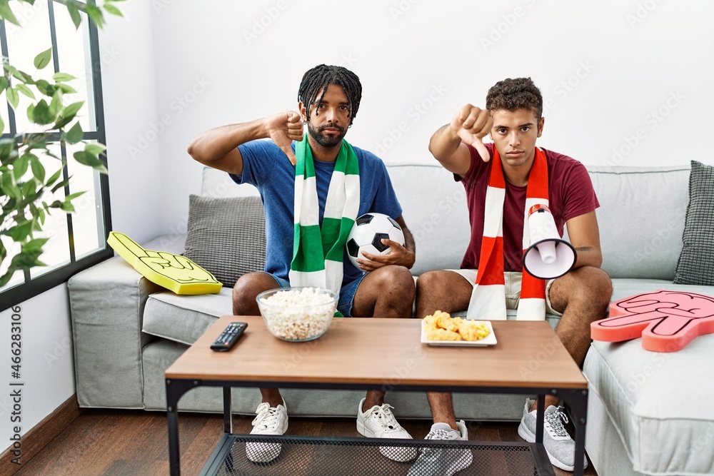 Young hispanic brothers football hooligans holding ball and megaphone ...