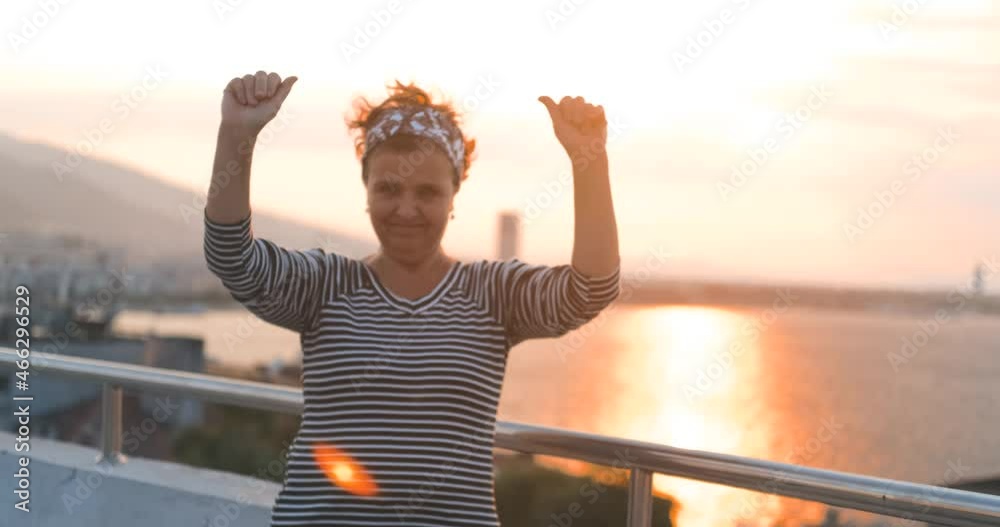 Sympathetic old senior woman is smiling to camera and weaving in ...