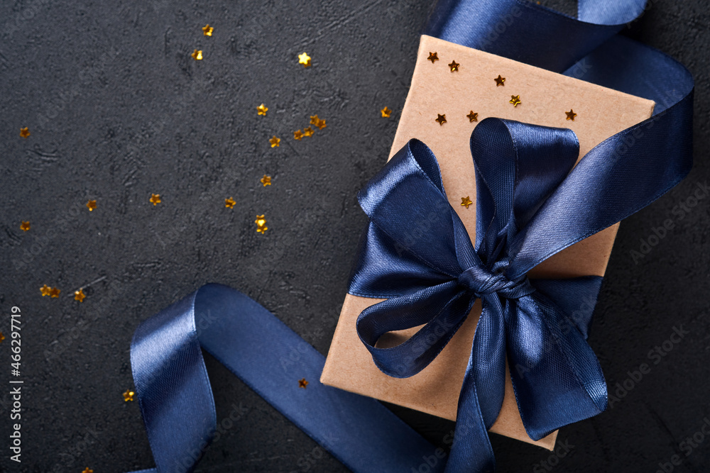 Holiday gift box or present with blue ribbon, golden confetti and gold ...