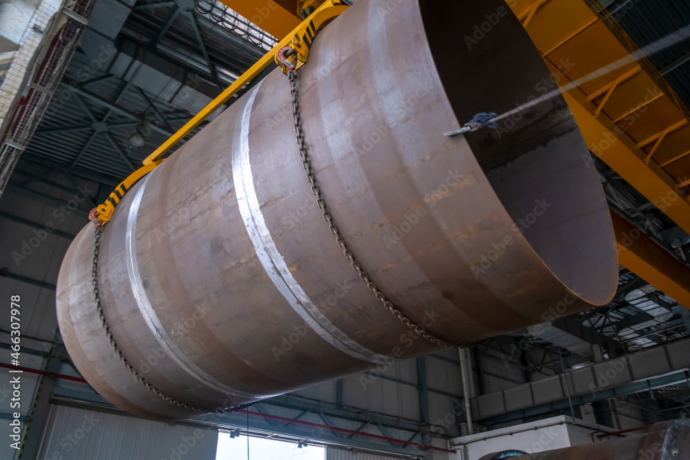 Moving pipes inside the workshop with an overhead crane using a ...