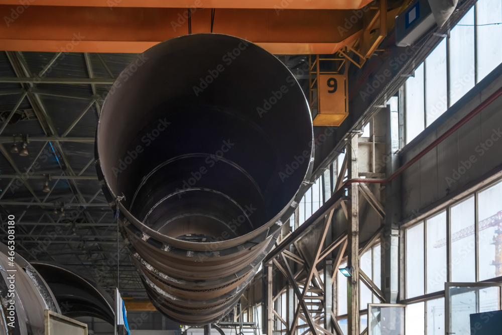 Moving pipes inside the workshop with an overhead crane using a ...