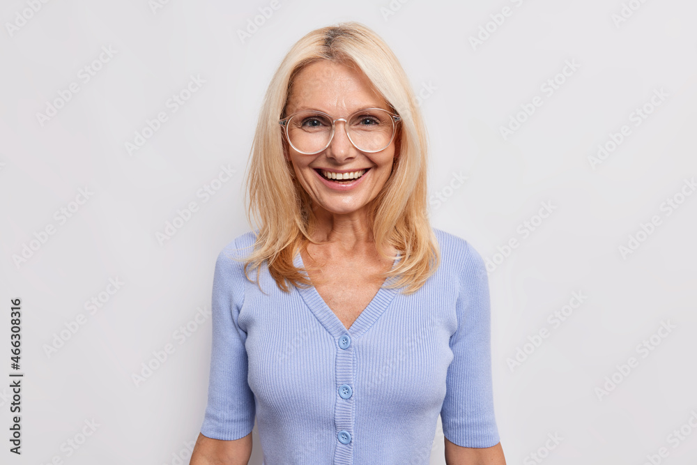 Horizontal shot of good looking woman with blonde hair smiles joyfully ...