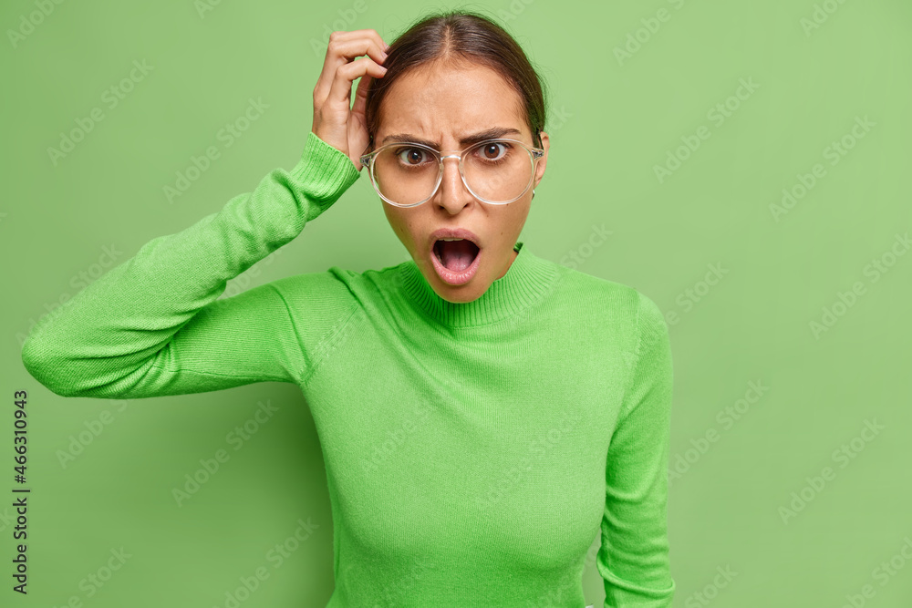 Outraged indignant brunette woman scratches head keeps mouth widely ...