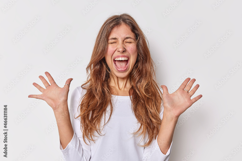 Horizontal Shot Of Emotional Long Haired Woman Raises Palms And