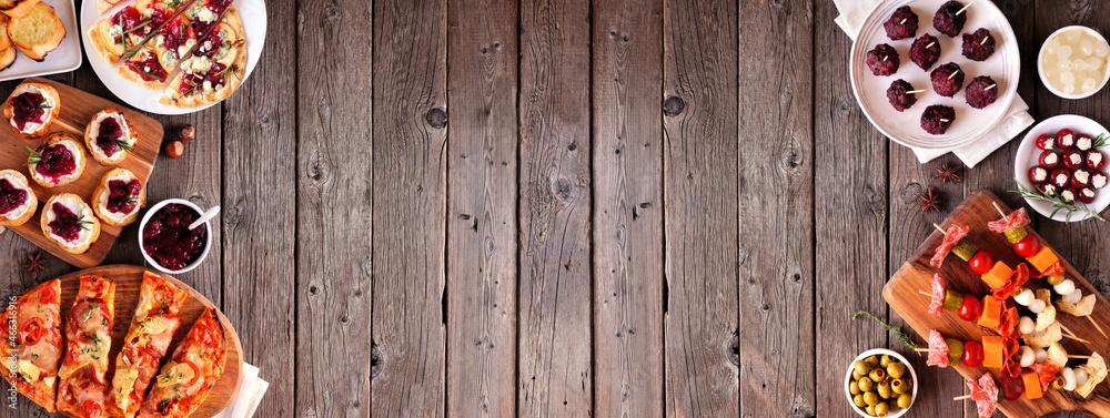 Winter holiday theme appetizers. Above view double border on a dark ...